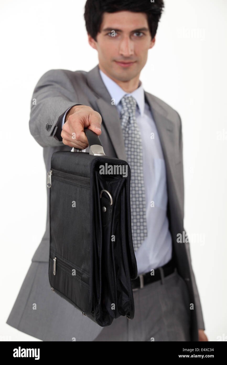 Businessman giving his briefcase Stock Photo - Alamy