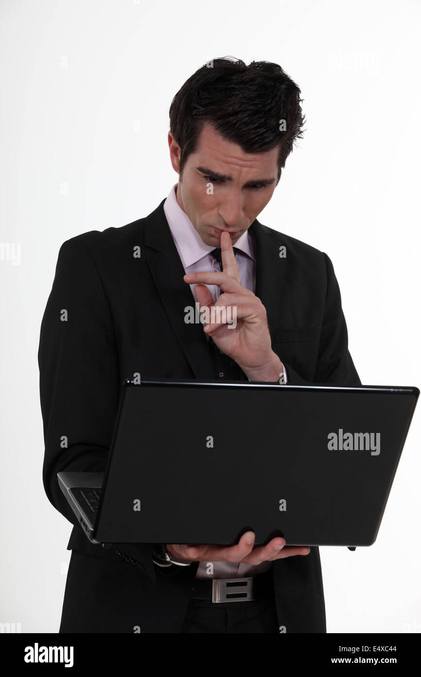 businessman standing with laptop computer Stock Photo - Alamy