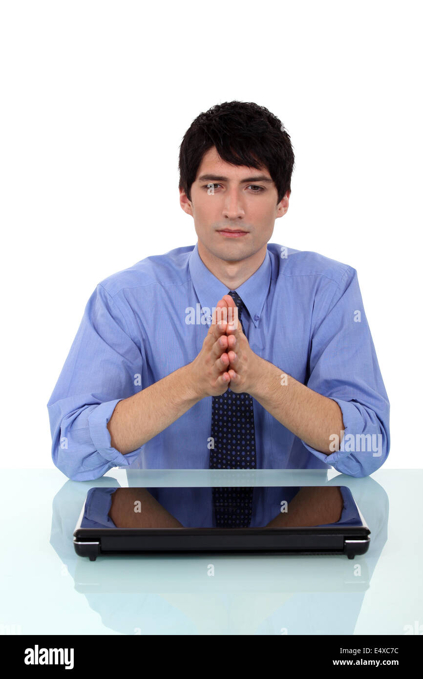 Businessman praying at desk Stock Photo - Alamy