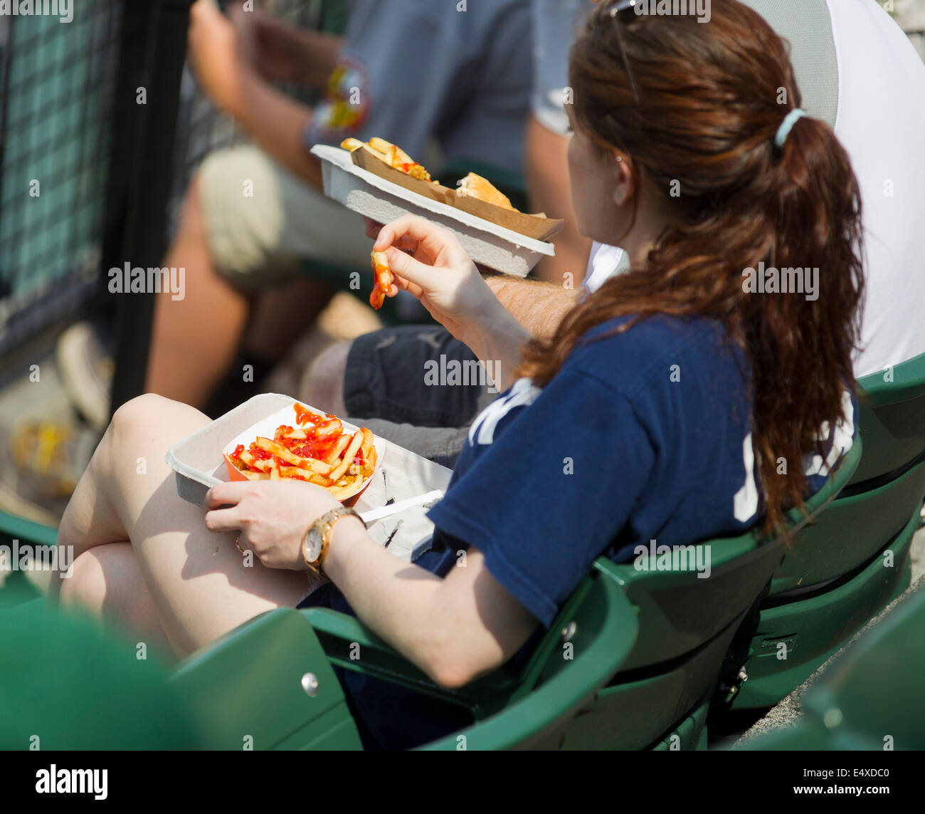 Fan eating french fries at a baseball game Stock Photo - Alamy
