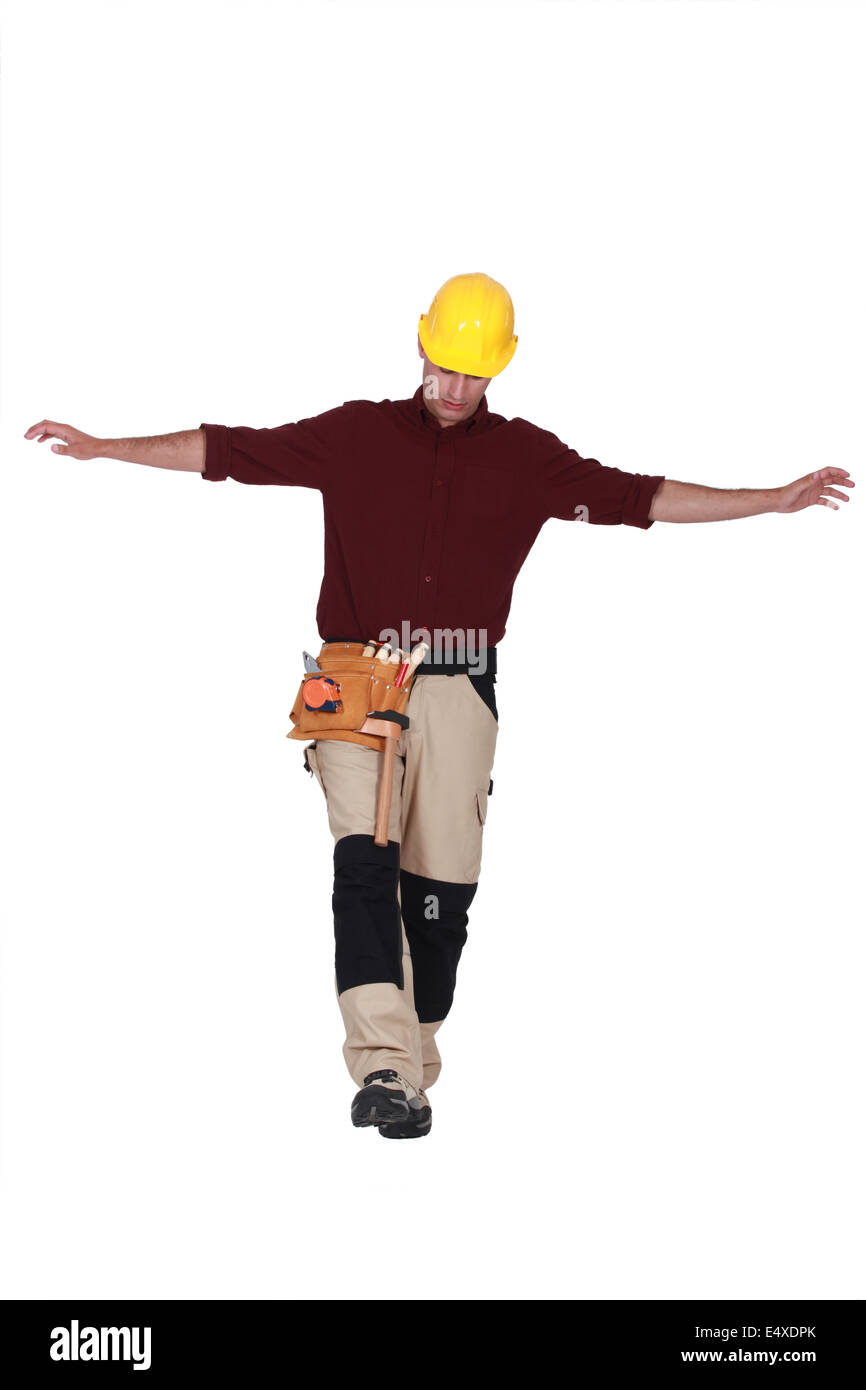 Builder balancing on one leg Stock Photo - Alamy
