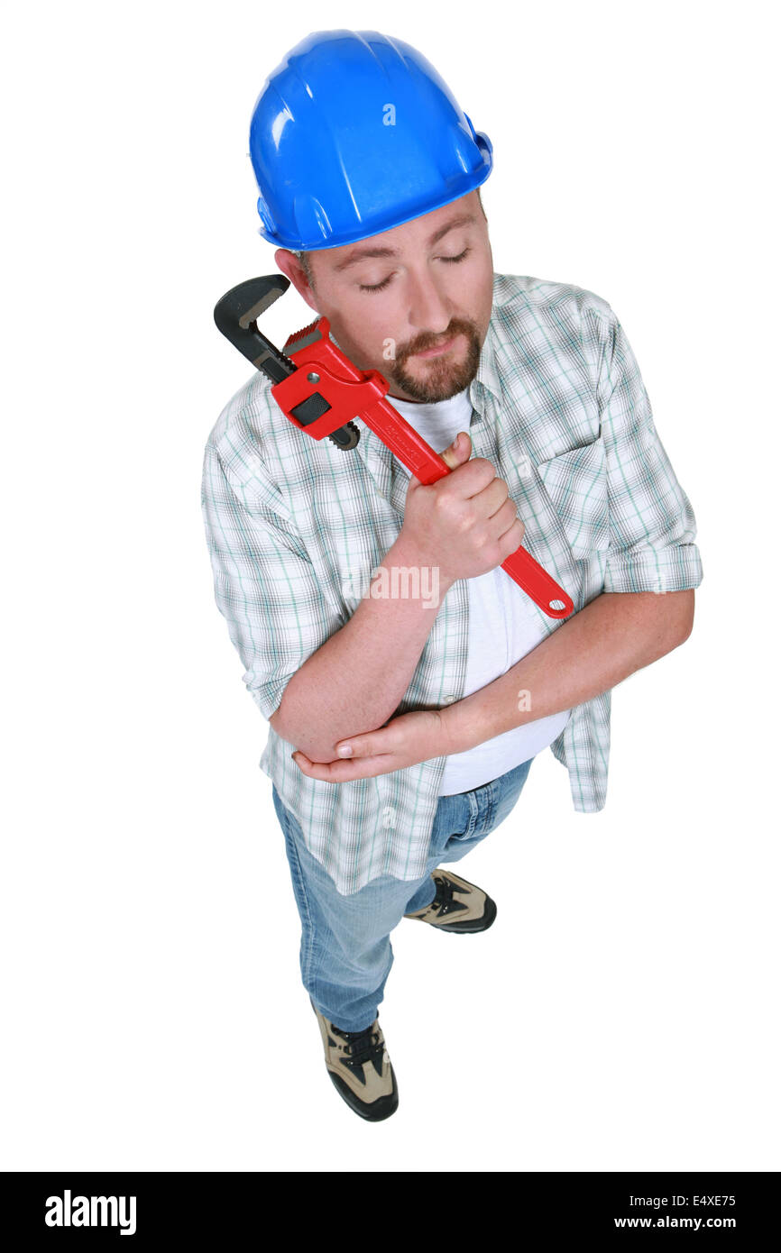 Tired plumber holding wrench Stock Photo - Alamy