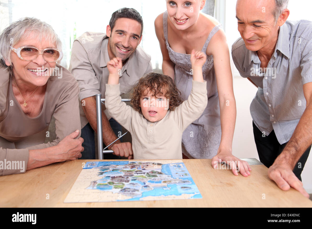Family gathered around jigsaw puzzle Stock Photo - Alamy