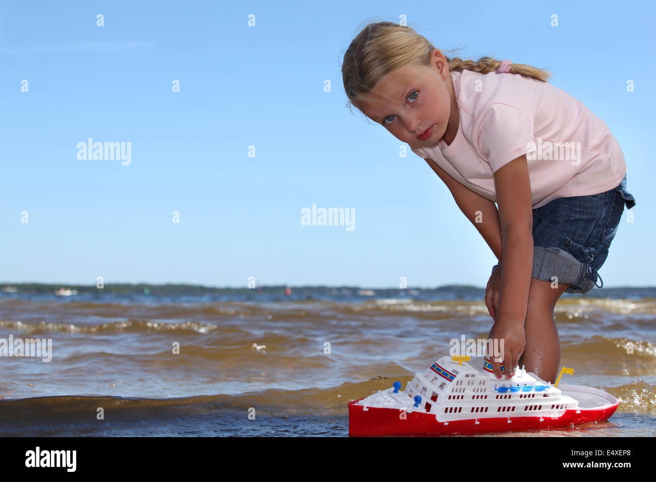 Girl playing with boat Stock Photo - Alamy