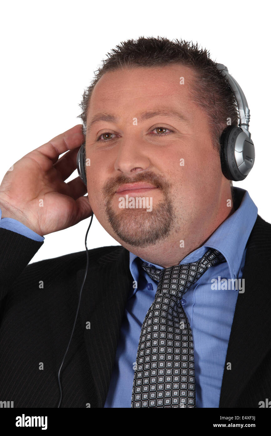 Businessman listening to headphones Stock Photo - Alamy