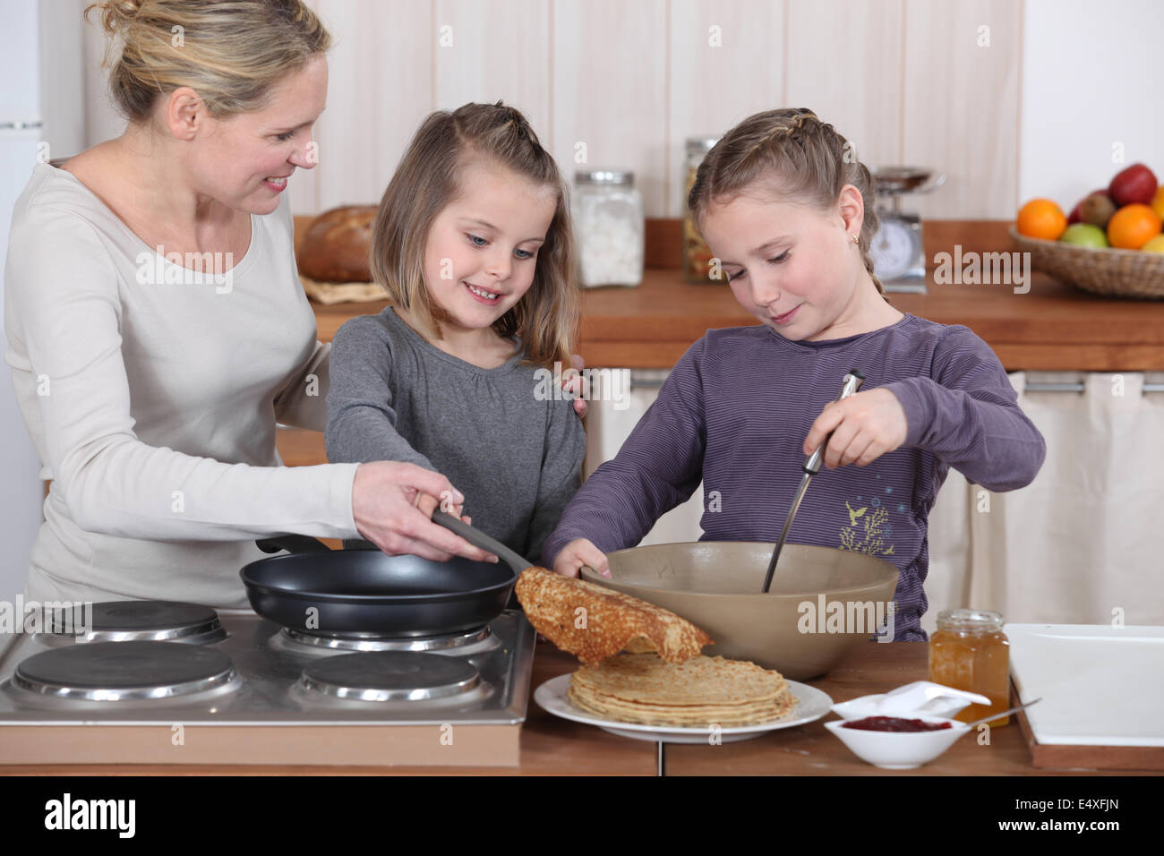 Mother and daughters making pancakes Stock Photo - Alamy