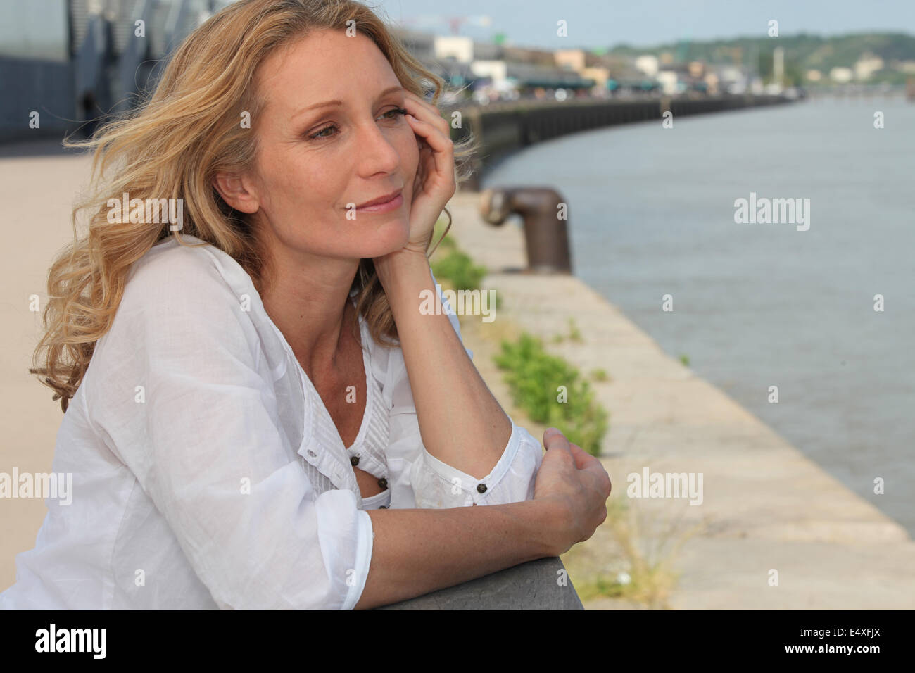 Woman contemplating life by the water's edge Stock Photo - Alamy