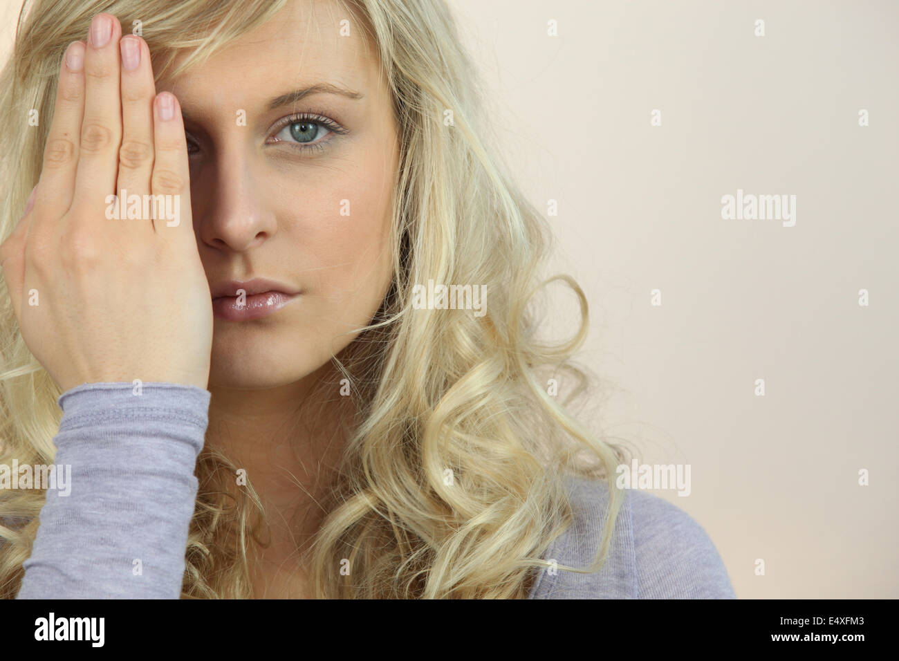 Woman covering one eye Stock Photo - Alamy