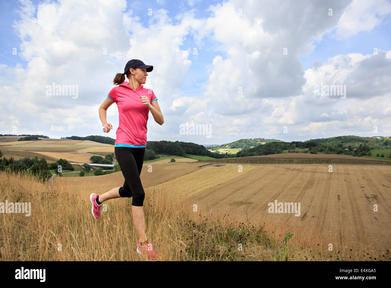 a woman running through the rural landscape Stock Photo - Alamy