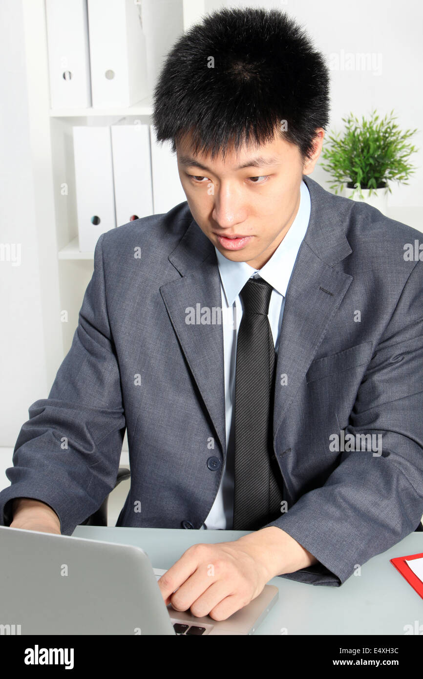 Professional Asian man focusing at his desk Stock Photo - Alamy
