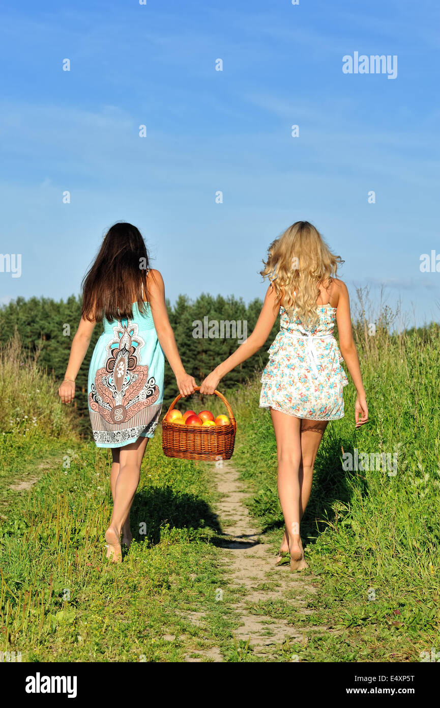 Two beautiful women walking at the meadow Stock Photo - Alamy
