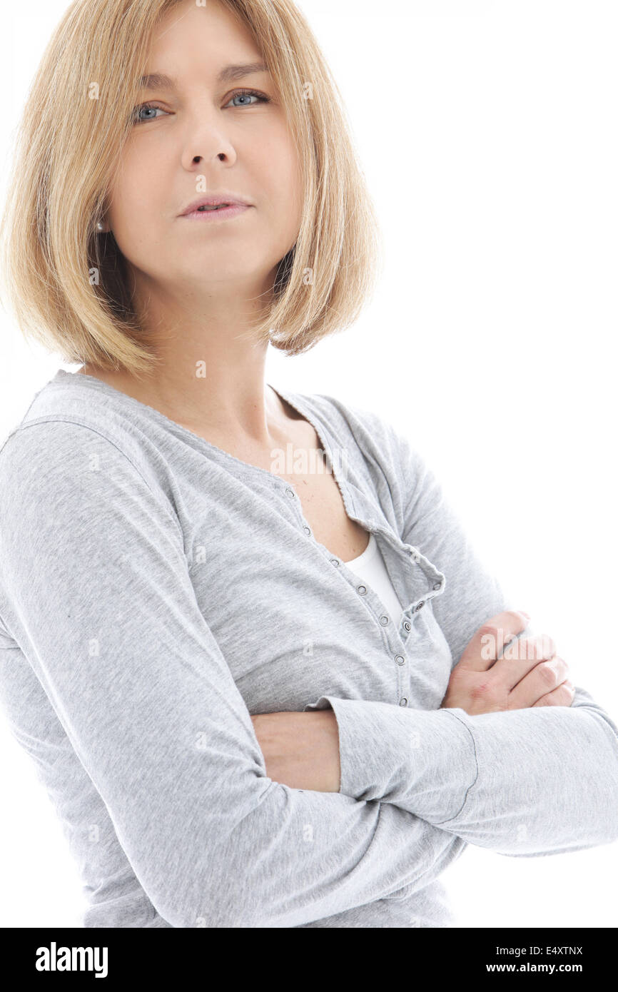 Thoughtful woman standing with folded arms Stock Photo - Alamy
