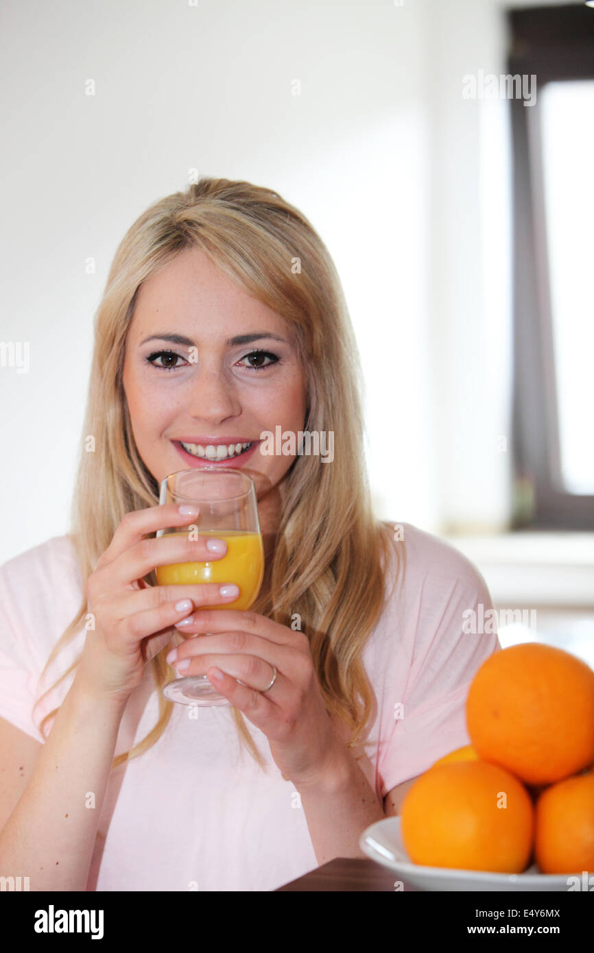 Young woman drinking fresh orange juice Stock Photo - Alamy