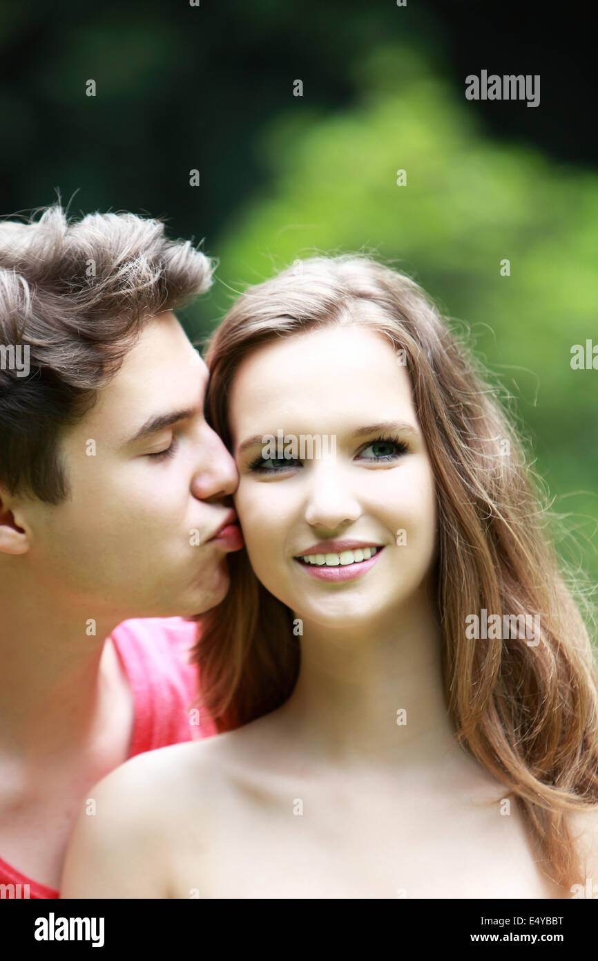 Young man kissing his girlfriend Stock Photo - Alamy
