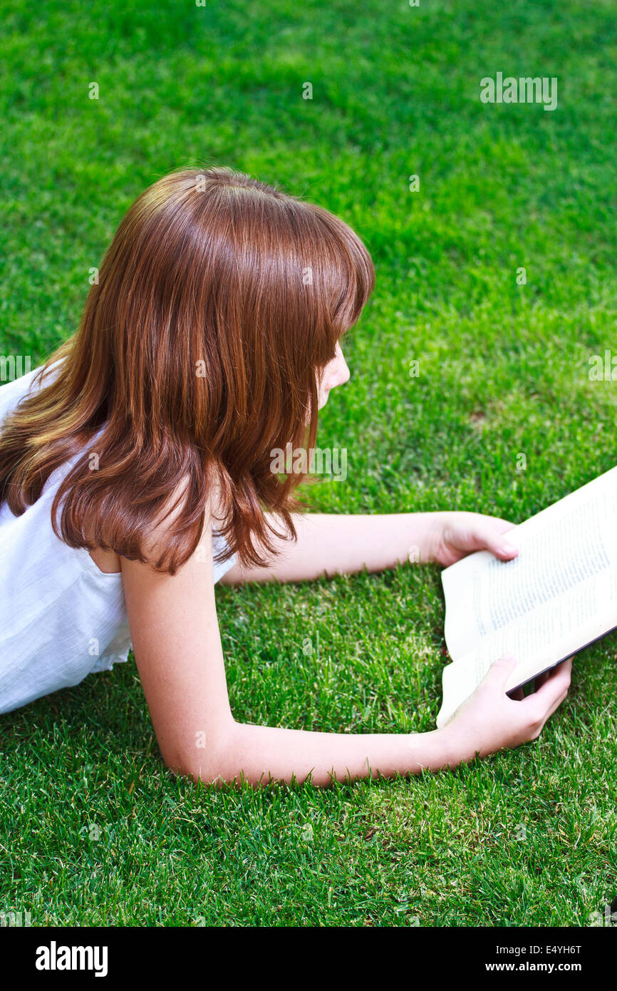 Young beautiful girl reading a book outdoor Stock Photo - Alamy