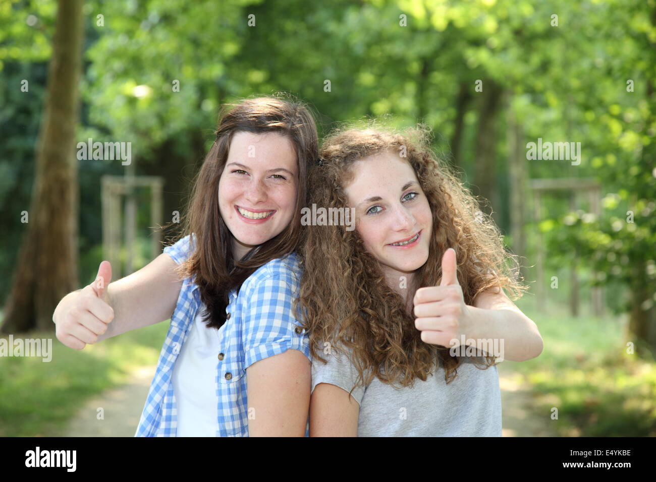 Two teenage students giving a thumbs up Stock Photo - Alamy