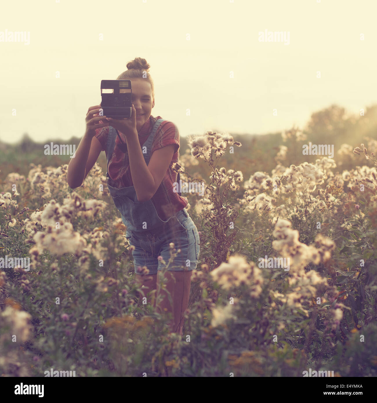 Girl photographer taking photo in the field Stock Photo - Alamy