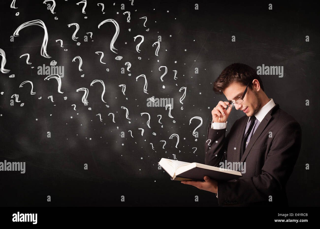 Young man reading a book with question marks coming out from it Stock ...