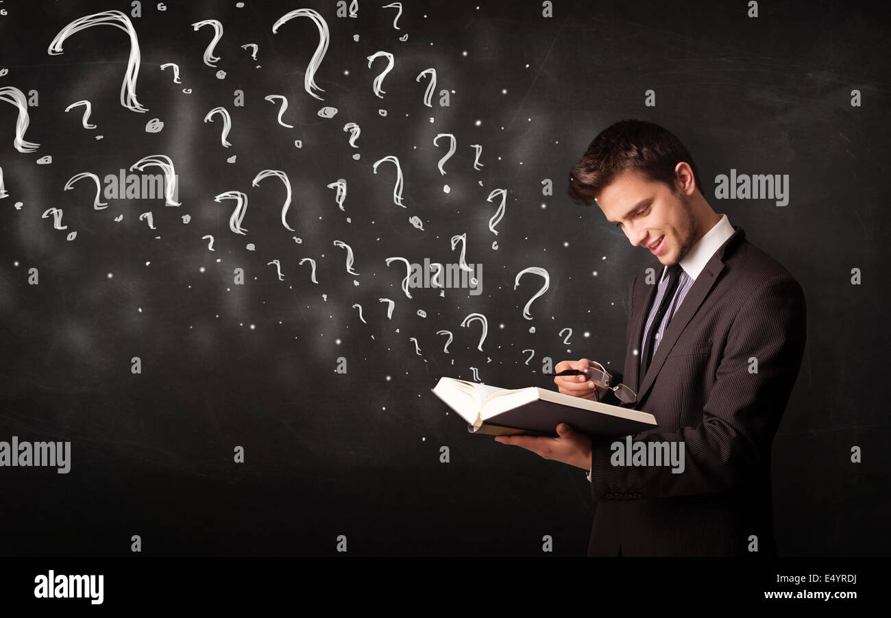 Young man reading a book with question marks coming out from it Stock ...