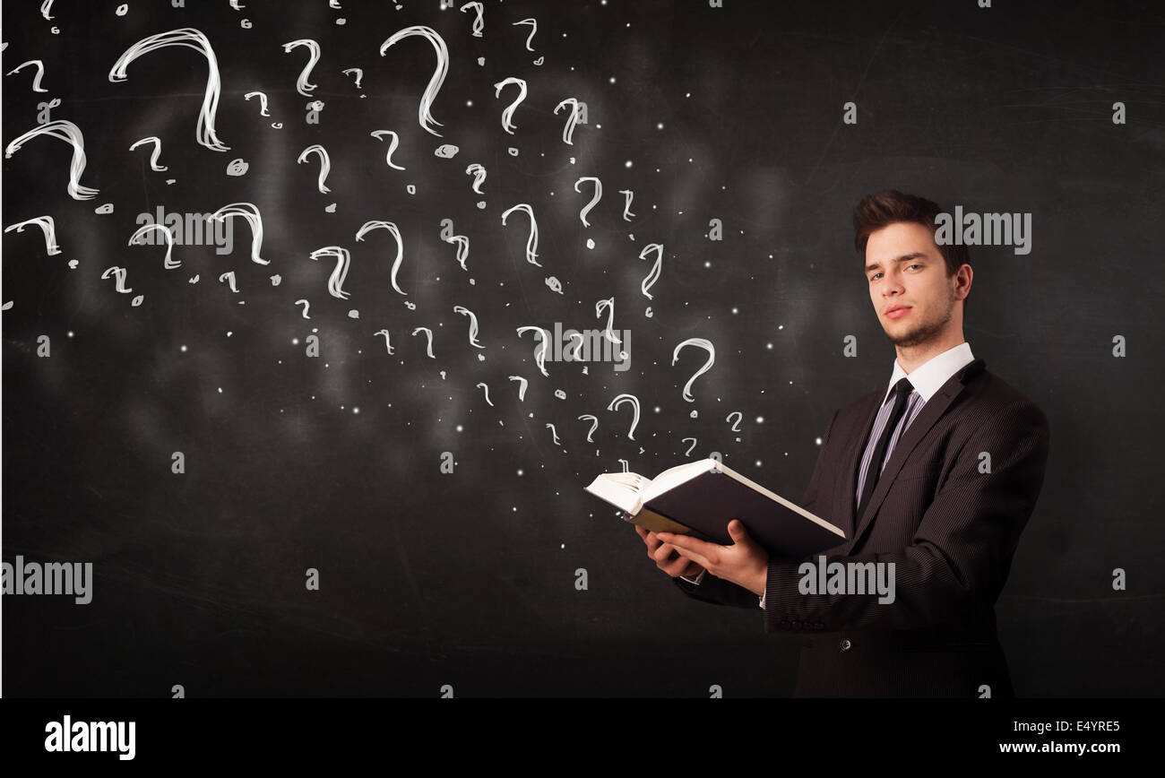 Young man reading a book with question marks coming out from it Stock ...