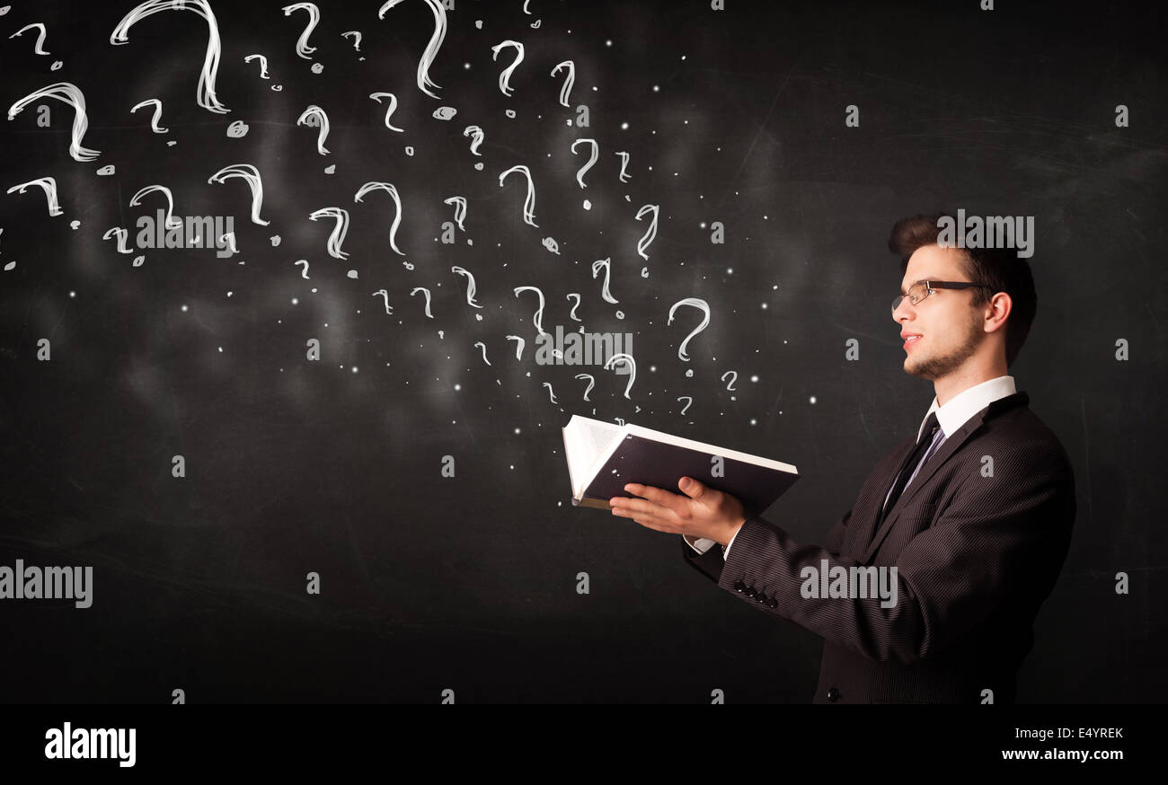 Young man reading a book with question marks coming out from it Stock ...