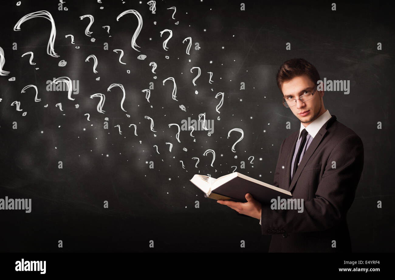 Young man reading a book with question marks coming out from it Stock ...