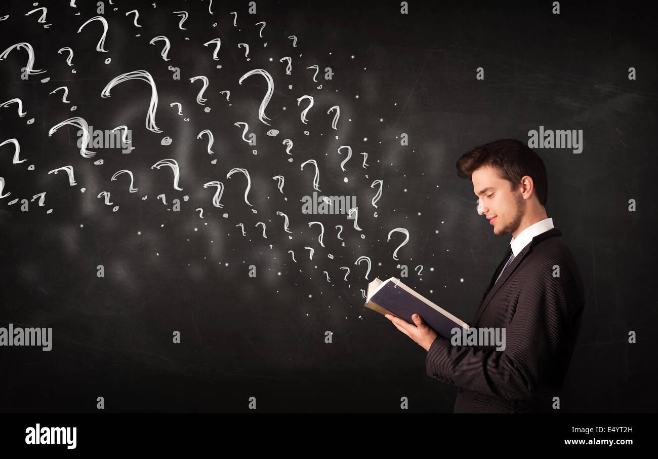 Young man reading a book with question marks coming out from it Stock ...