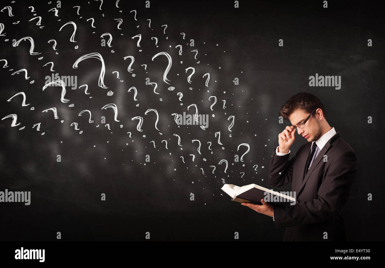 Young man reading a book with question marks coming out from it Stock ...