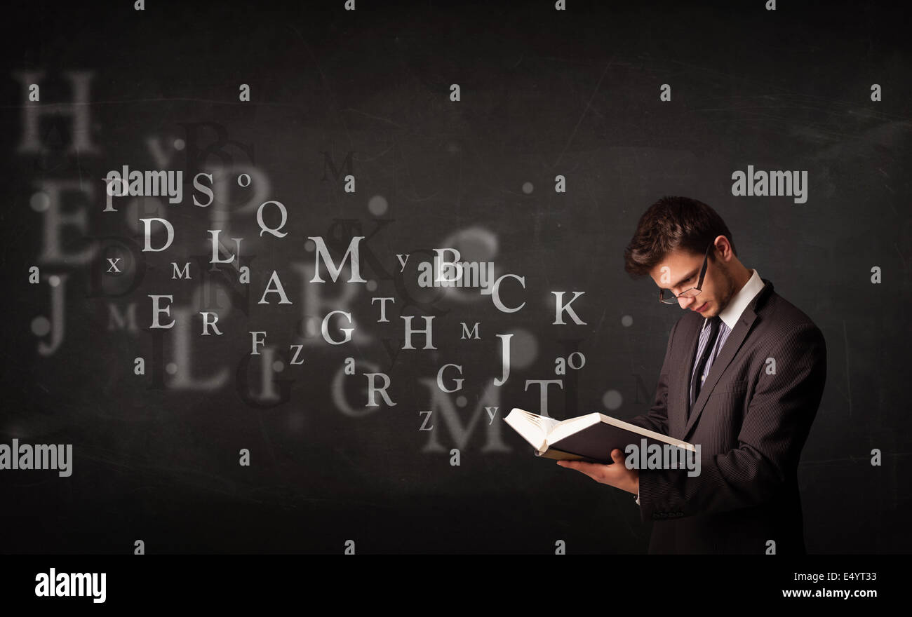 Young man reading a book with alphabet letters Stock Photo - Alamy