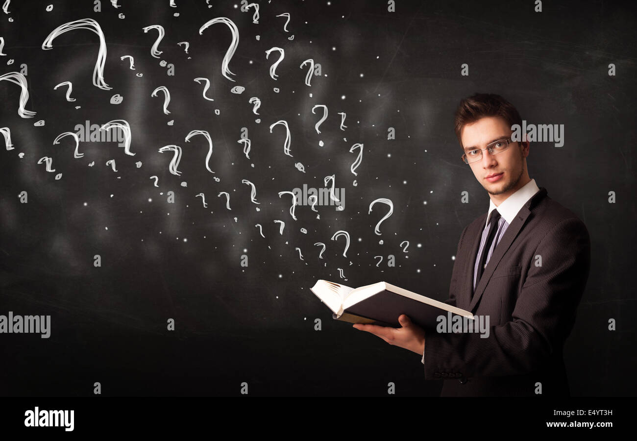 Young man reading a book with question marks coming out from it Stock ...