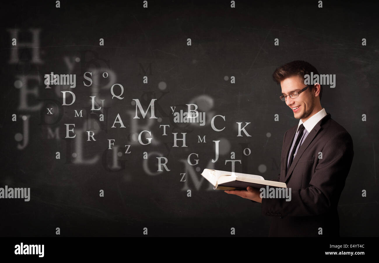 Young man reading a book with alphabet letters Stock Photo - Alamy