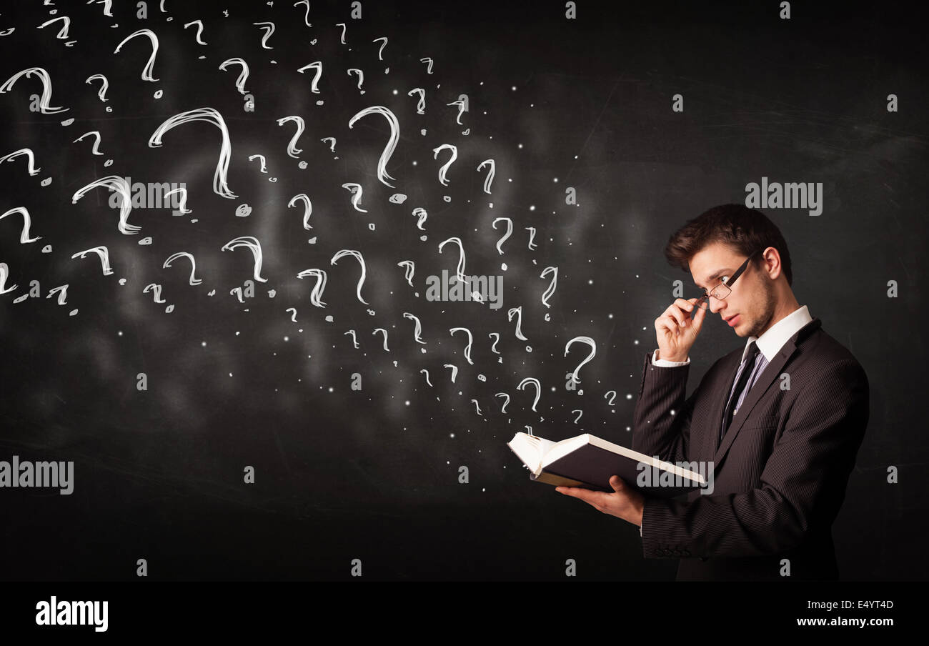 Young man reading a book with question marks coming out from it Stock ...