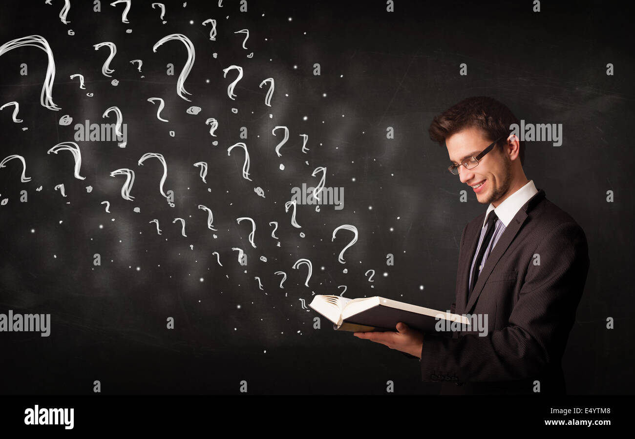 Young man reading a book with question marks coming out from it Stock ...