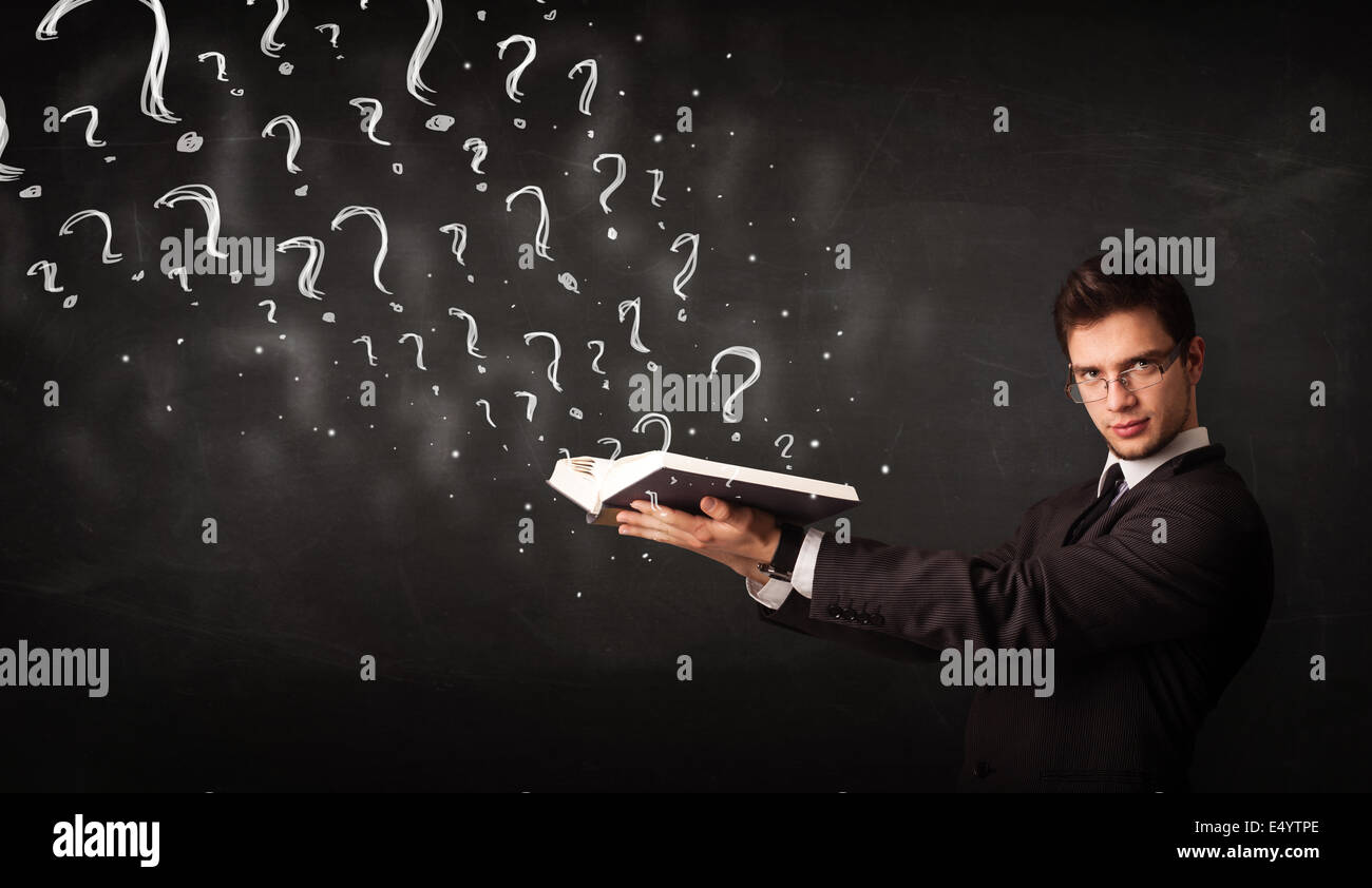 Young man reading a book with question marks coming out from it Stock ...