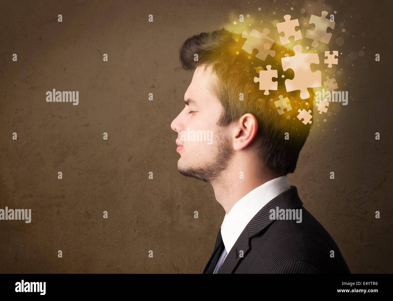 Young person thinking with glowing puzzle mind Stock Photo - Alamy