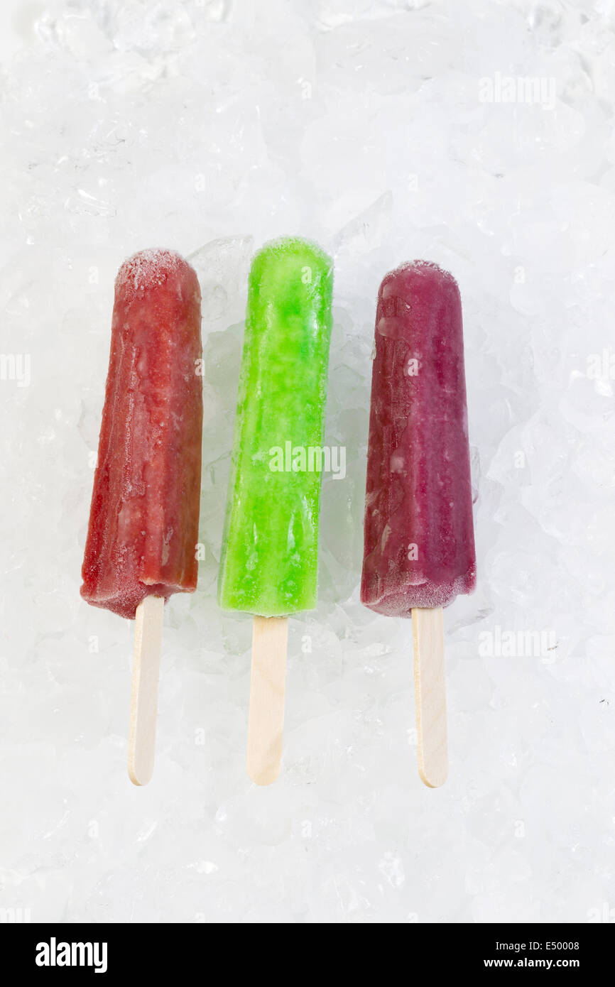 Vertical view of colorful frozen fruit popsicles on shaved ice Stock ...