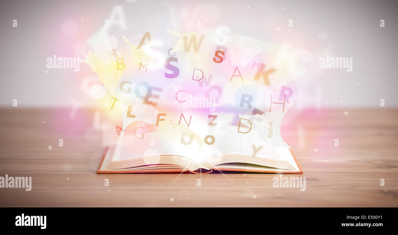 Open book with glowing letters on concrete background Stock Photo - Alamy