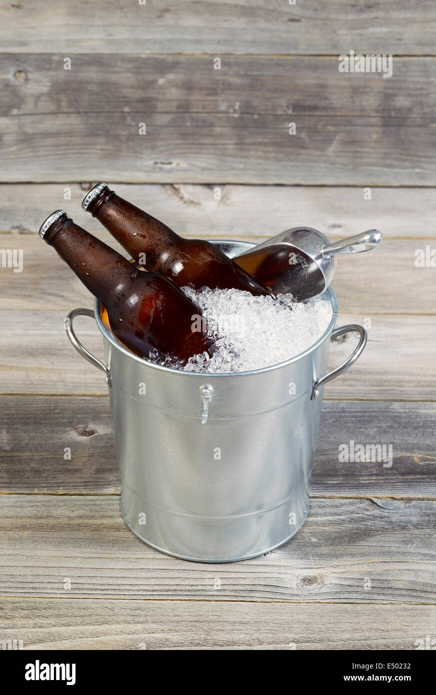 Vertical view of two unopened bottles of beer sitting inside metal ...