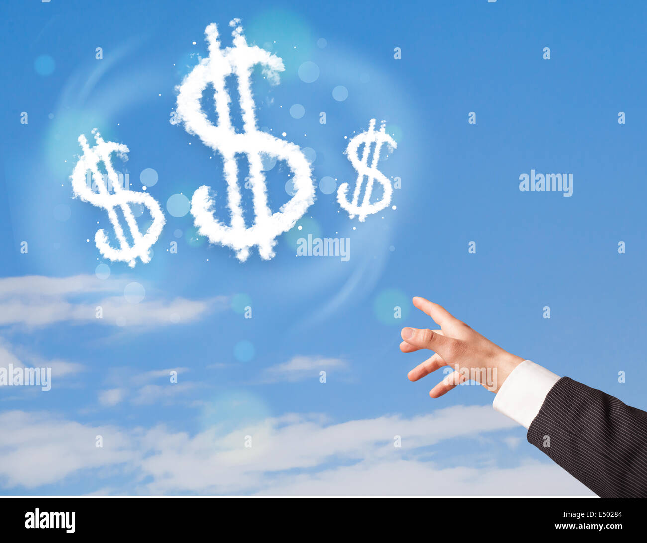 Hand pointing at dollar sign clouds on blue sky Stock Photo - Alamy