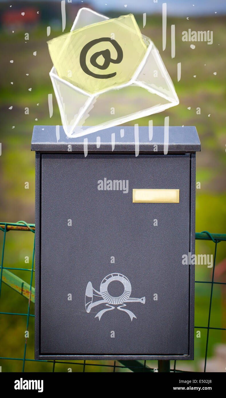 Envelope with email sign dropping into mailbox Stock Photo - Alamy