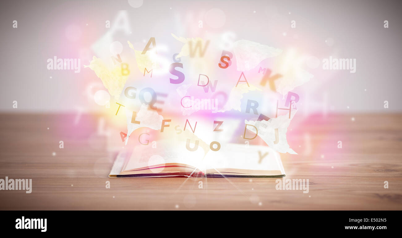 Open book with glowing letters on concrete background Stock Photo - Alamy