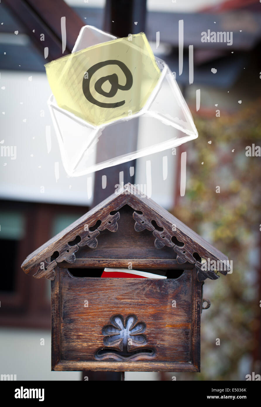 Envelope with email sign dropping into mailbox Stock Photo - Alamy