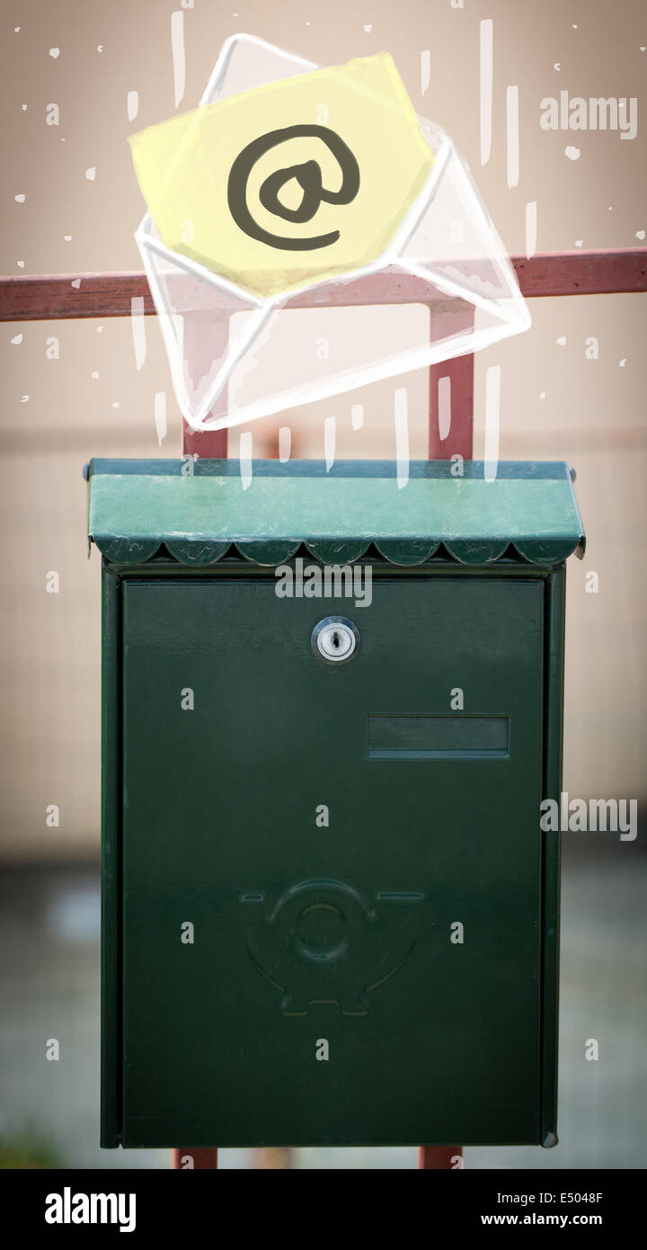 Envelope with email sign dropping into mailbox Stock Photo - Alamy