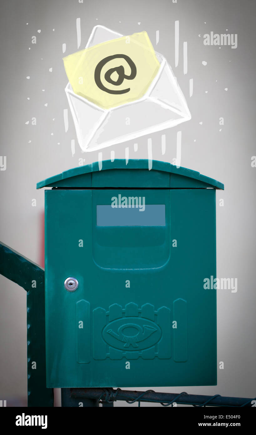 Envelope with email sign dropping into mailbox Stock Photo - Alamy