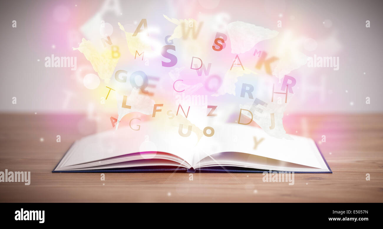 Open book with glowing letters on concrete background Stock Photo - Alamy