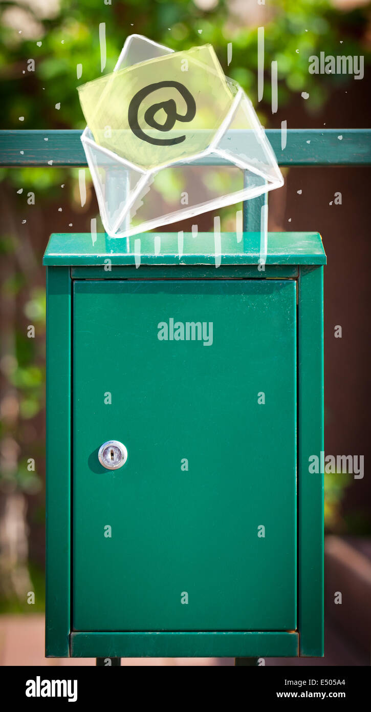 Envelope with email sign dropping into mailbox Stock Photo - Alamy