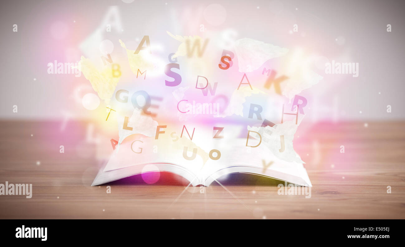 Open book with glowing letters on concrete background Stock Photo - Alamy