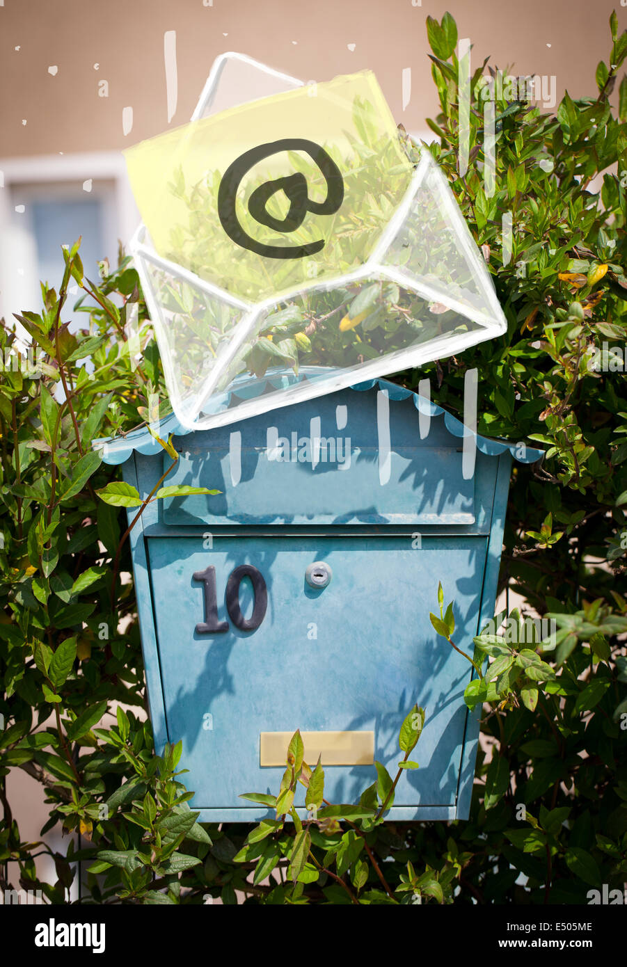 Envelope with email sign dropping into mailbox Stock Photo - Alamy