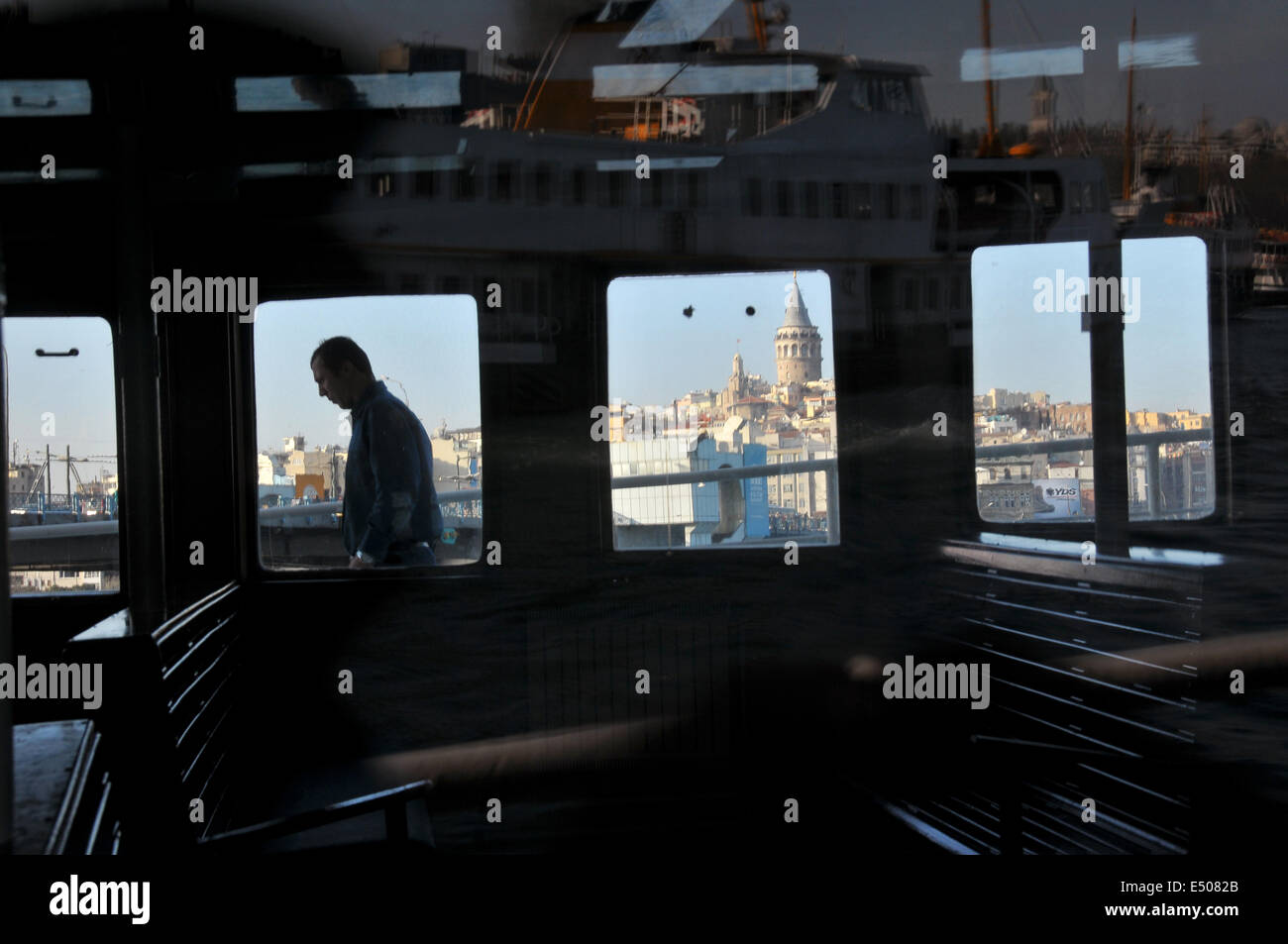 An old-style ferry with wooden seats docked at Eminönü pier. Galata ...