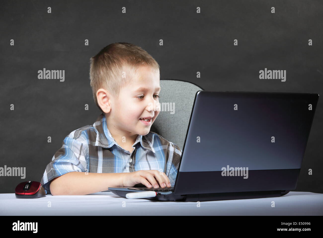 Computer addiction child with laptop notebook Stock Photo - Alamy